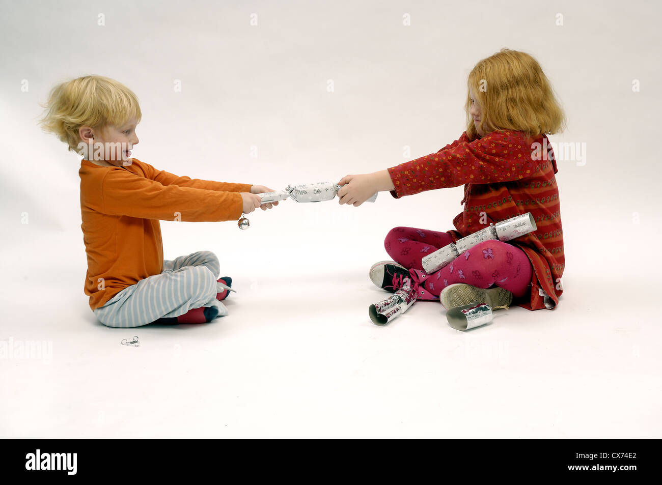 Boy and Girl Pulling Cracker Stock Photo - Alamy