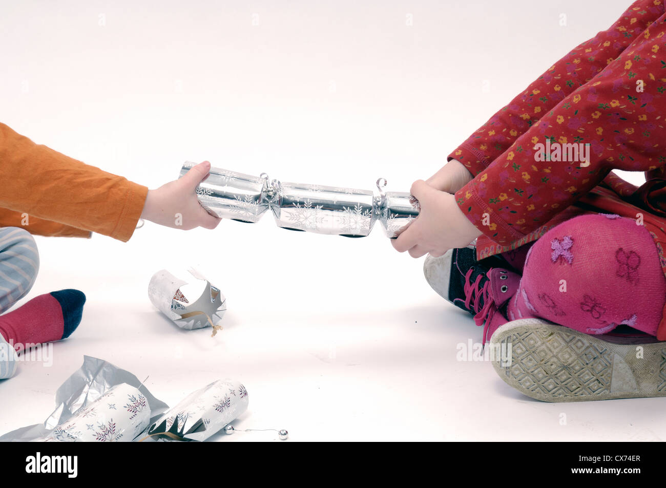Boy and Girl Pull a Cracker With Others In Pieces on Floor Stock Photo ...