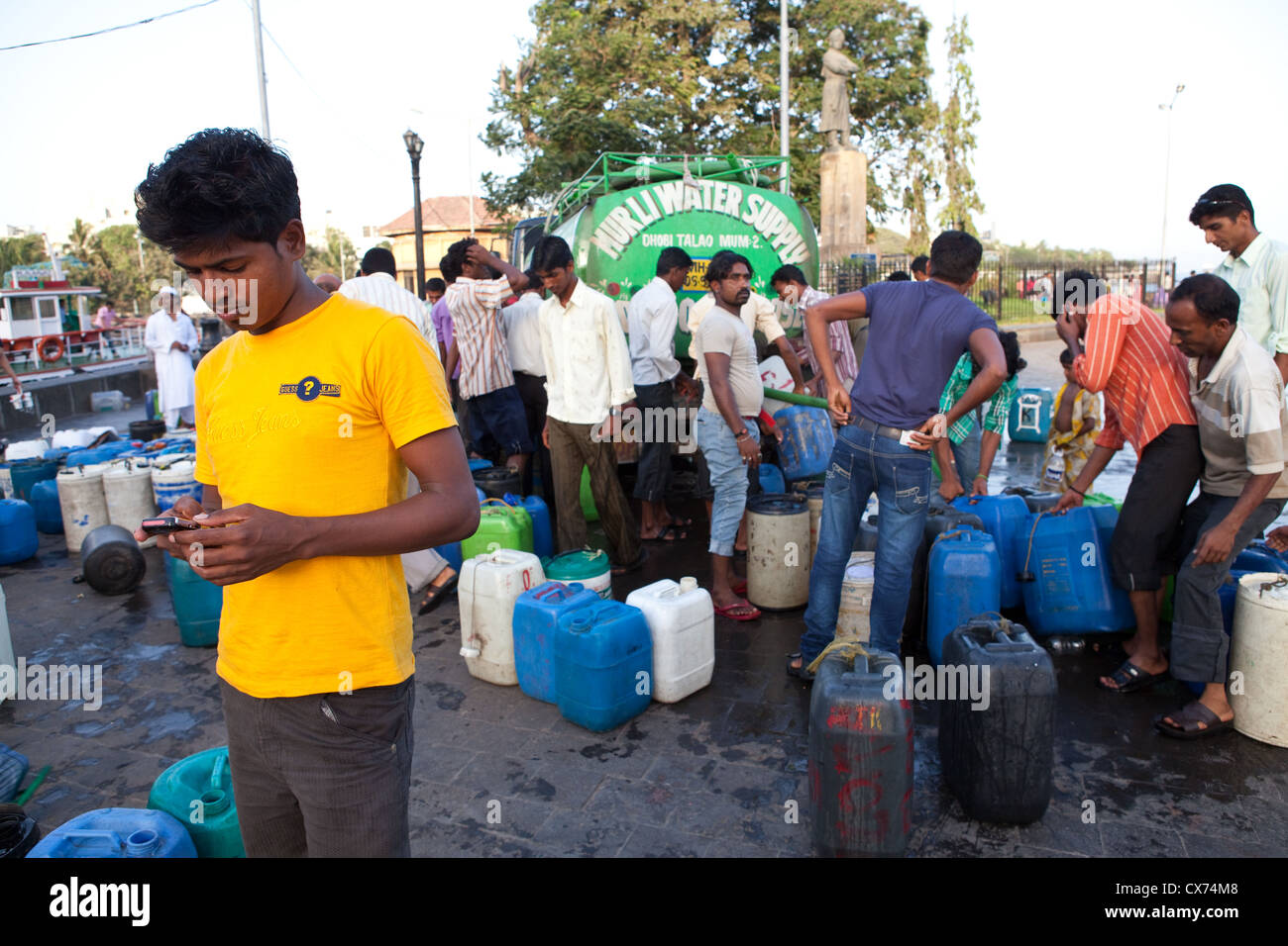 Indian men gathering water in containers near the port in Colaba ...