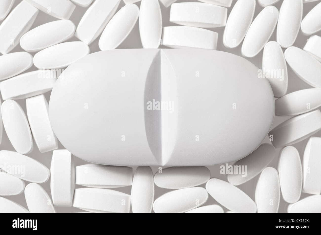 PILLS SUPPLEMENTS DRUGS CONCEPT One large pill among many smaller pills ...