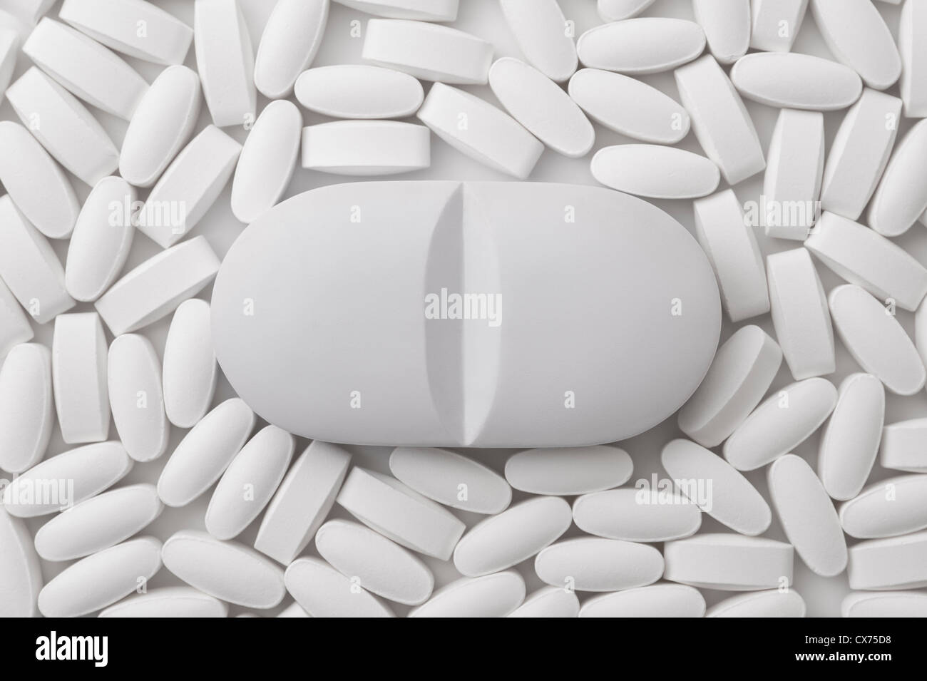 PILLS SUPPLEMENTS DRUGS CONCEPT One large pill among many smaller pills ...
