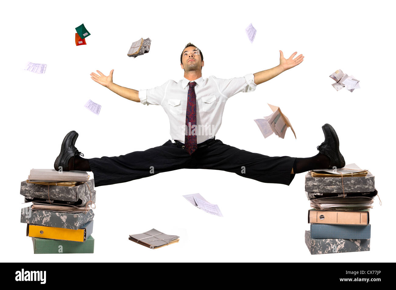 Businessman doing splits over stack of files with papers all around ...