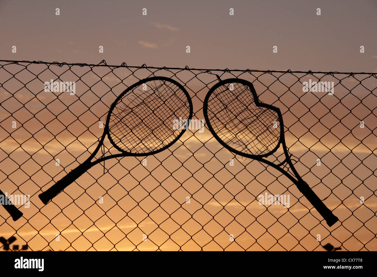 Old broken tennis rackets tied to fence at tennis club Stock Photo - Alamy