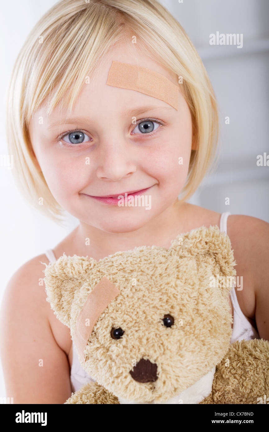 Little girl with band-aid on her face holding a teddy bear Stock Photo ...