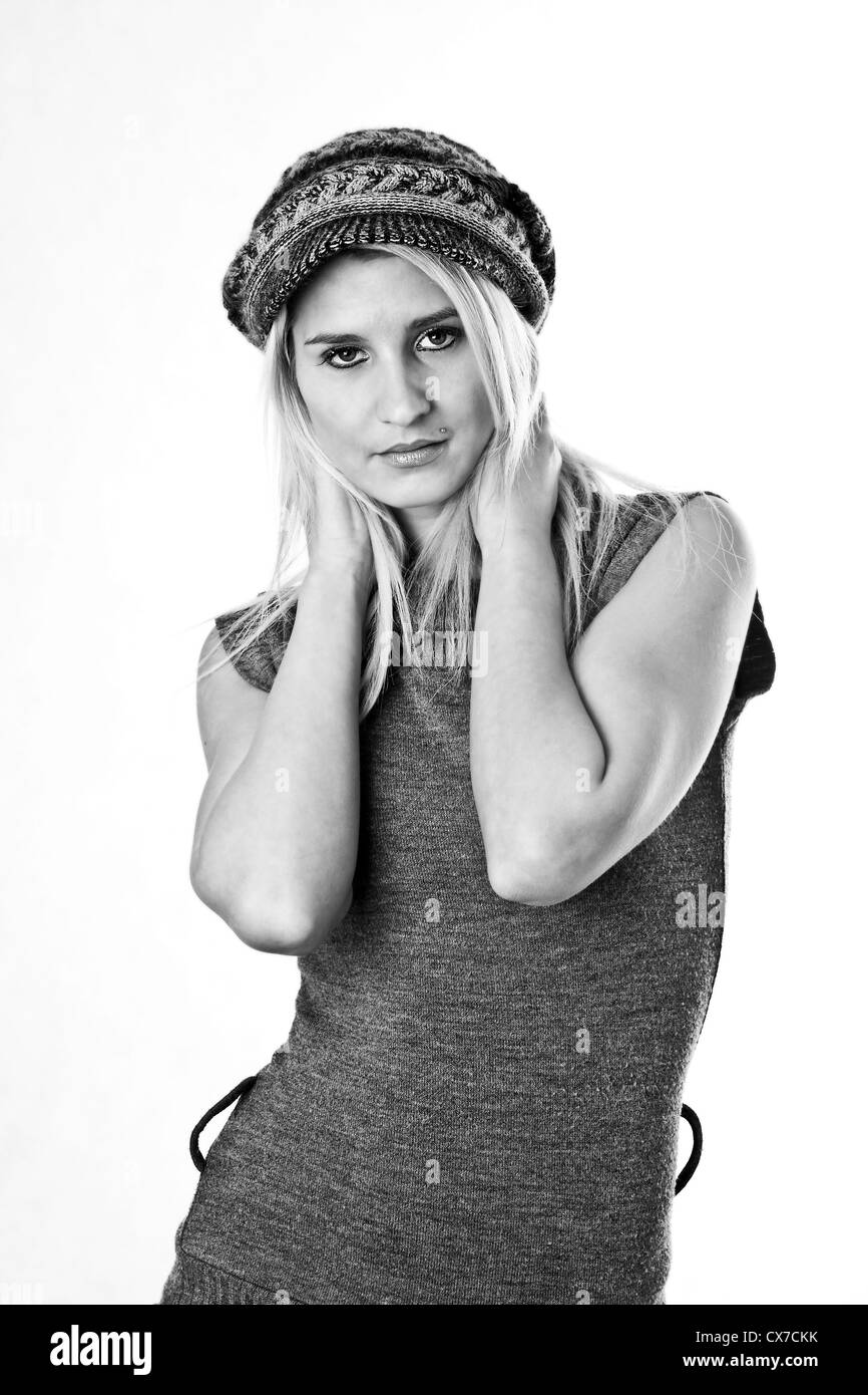 Fashionable young woman in gray sweater and cap, isolated on white ...