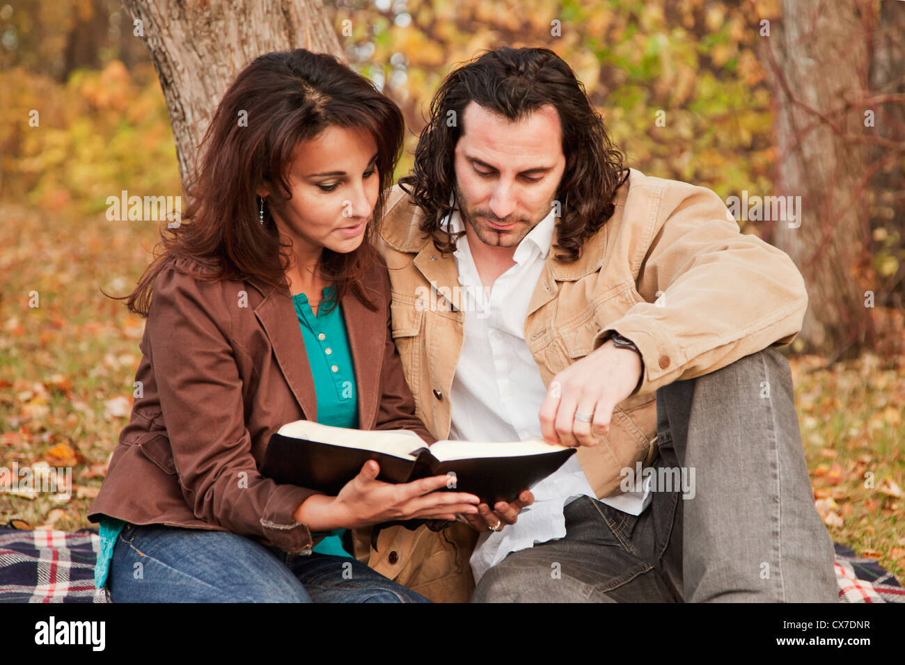 Married Couple Reading Bible Together In A Park In Autumn; Edmonton ...