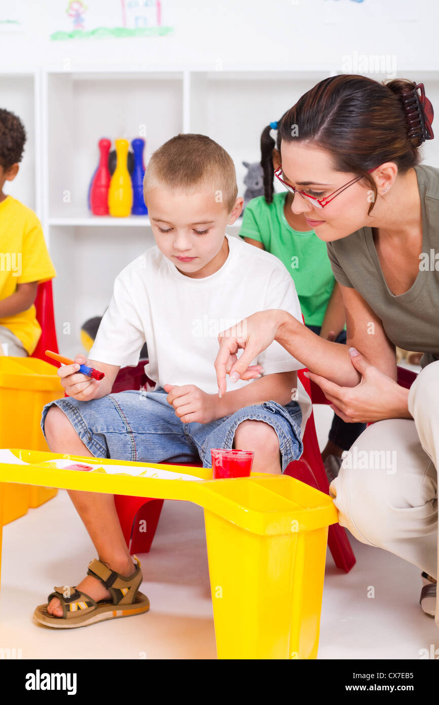 kindergarten teacher and preschool students in classroom Stock Photo ...