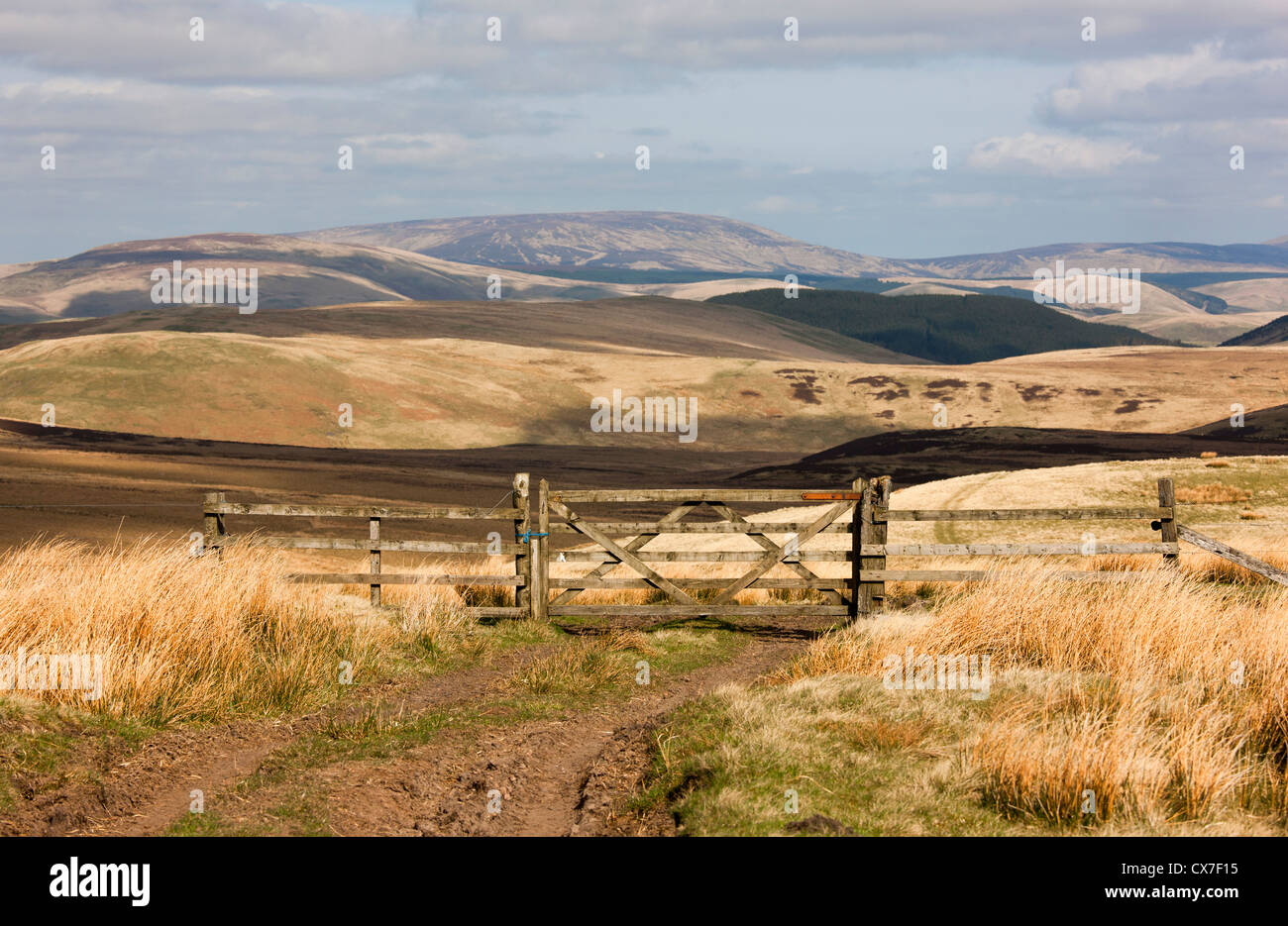 A Wooden Gate Across A Dirt Trail With A Rolling Hill Landscape In The ...