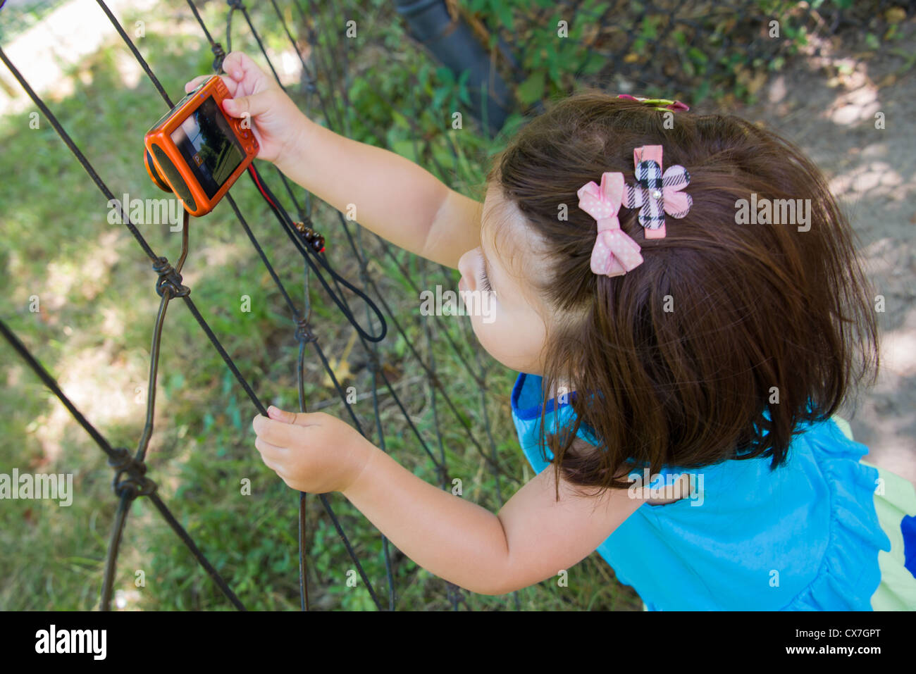 Child taking a photograph through a fence Stock Photo - Alamy