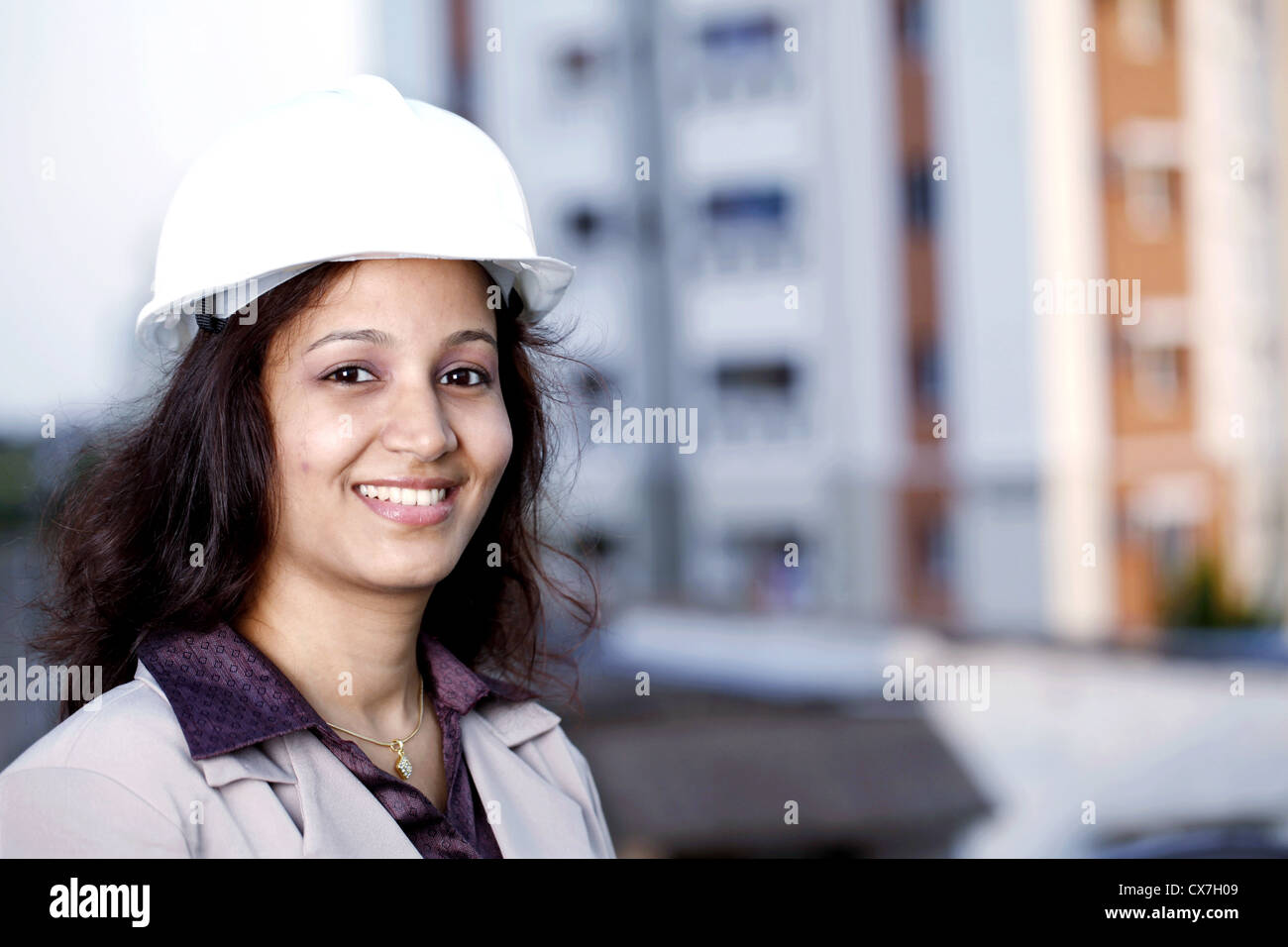 Smiling young Indian female architect at construction site Stock Photo ...