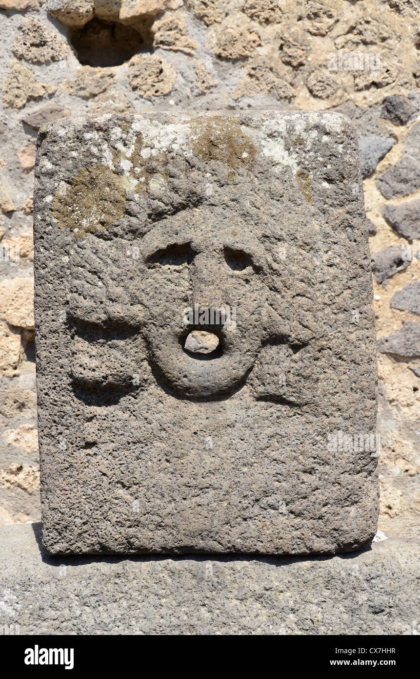 Pompeii ruins - carved head stone at water trough or well Stock Photo ...