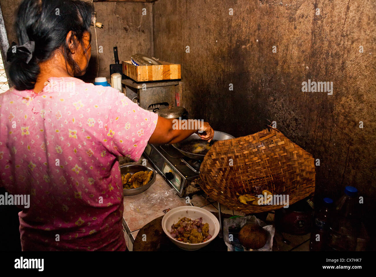 A Woman Preparing Food In A Makeshift Kitchen In Her Home Over A Trash ...