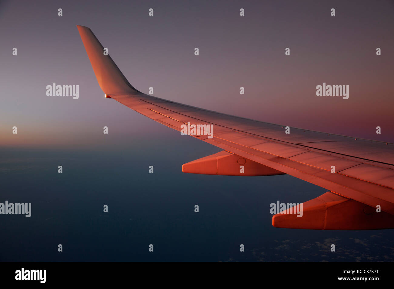 Jet above the clouds at dusk Stock Photo - Alamy