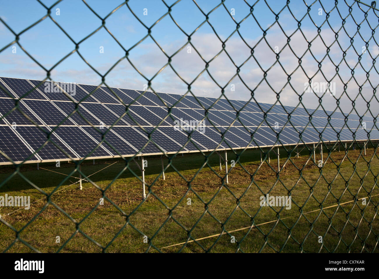 Solar panels behind chain link fence Stock Photo - Alamy