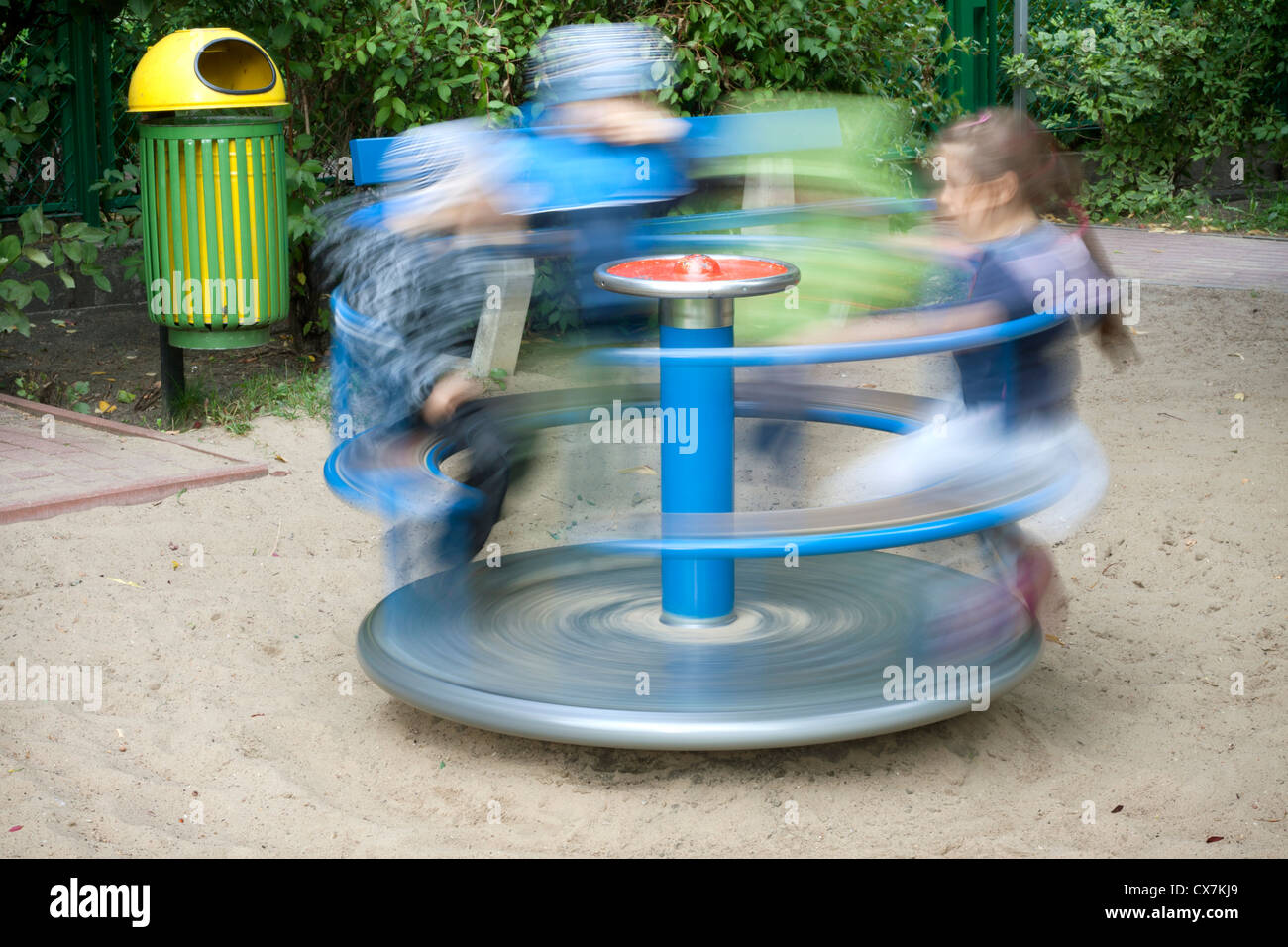 Carousel in motion and happy kids on playground Stock Photo - Alamy