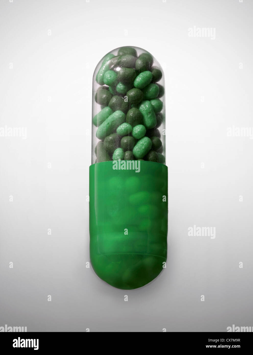 A vibrant green capsule pill, close-up Stock Photo - Alamy
