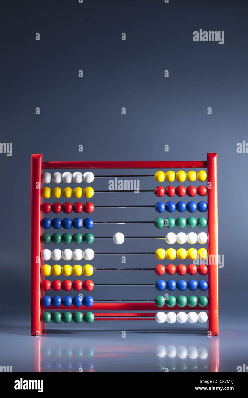 An abacus with neat rows of multi colored beads and a single white bead ...