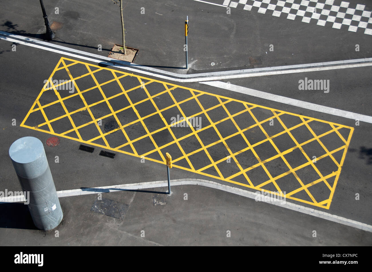Yellow lines on the street to mark 'no-stopping area' near a red light ...