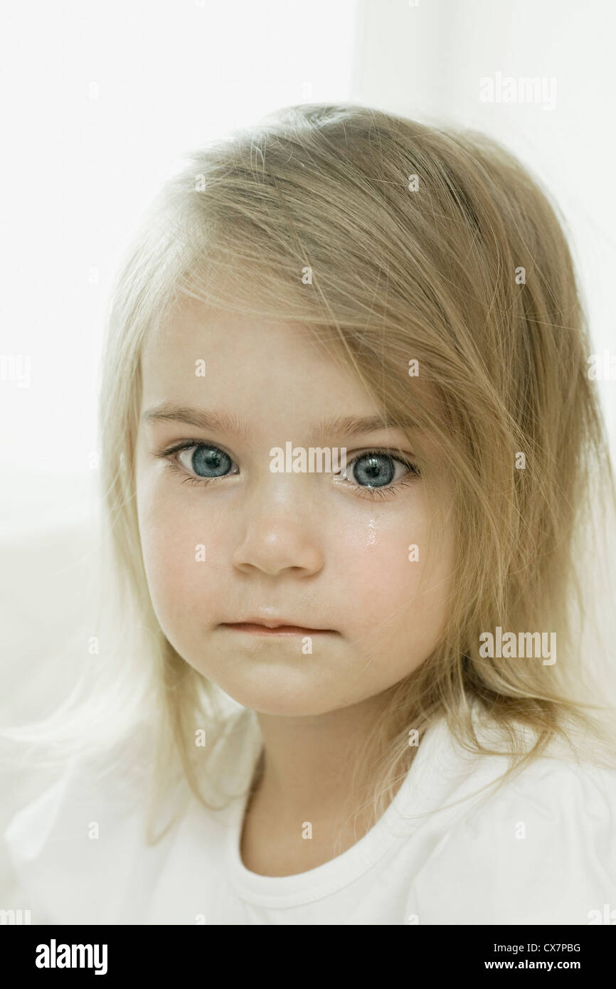 A young girl with a tear falling down her cheek Stock Photo - Alamy