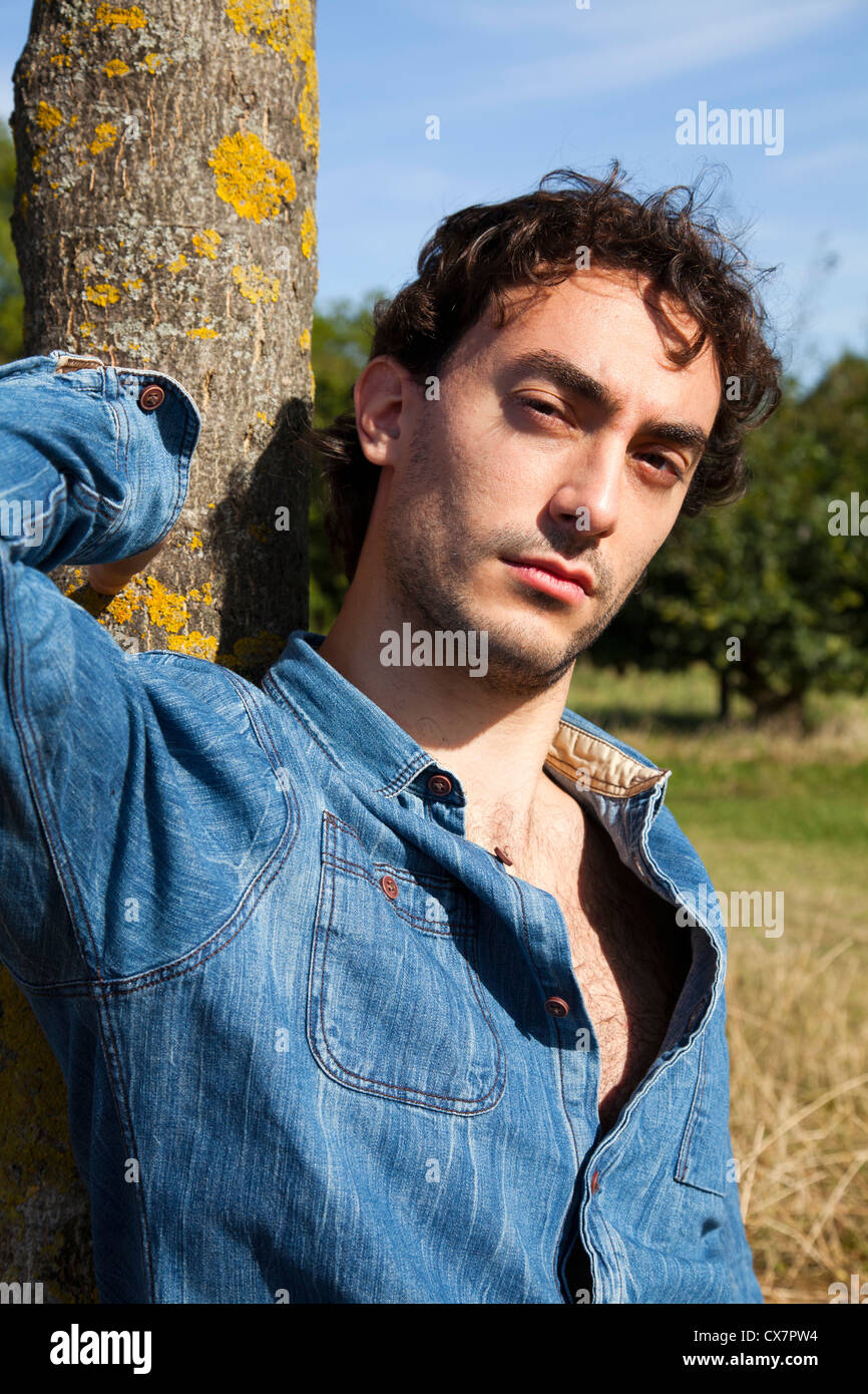 Man leaning against tree in park Stock Photo - Alamy