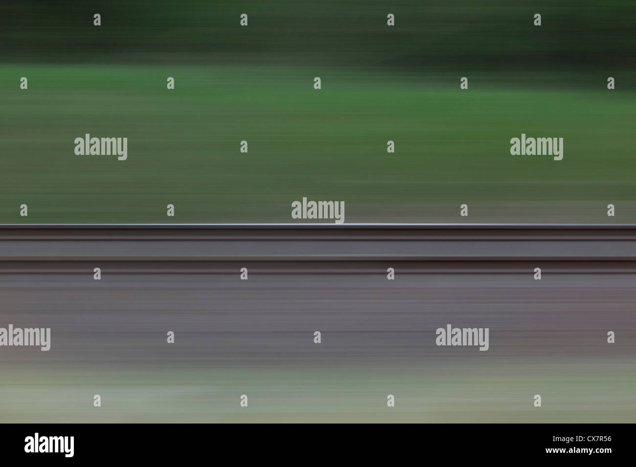 Railroad tracks and grass seen in blurred abstract pattern from moving ...
