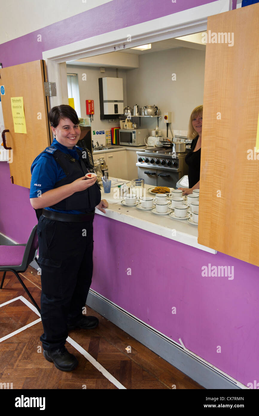 A British police community support officer (PCSO) having a tea break at ...