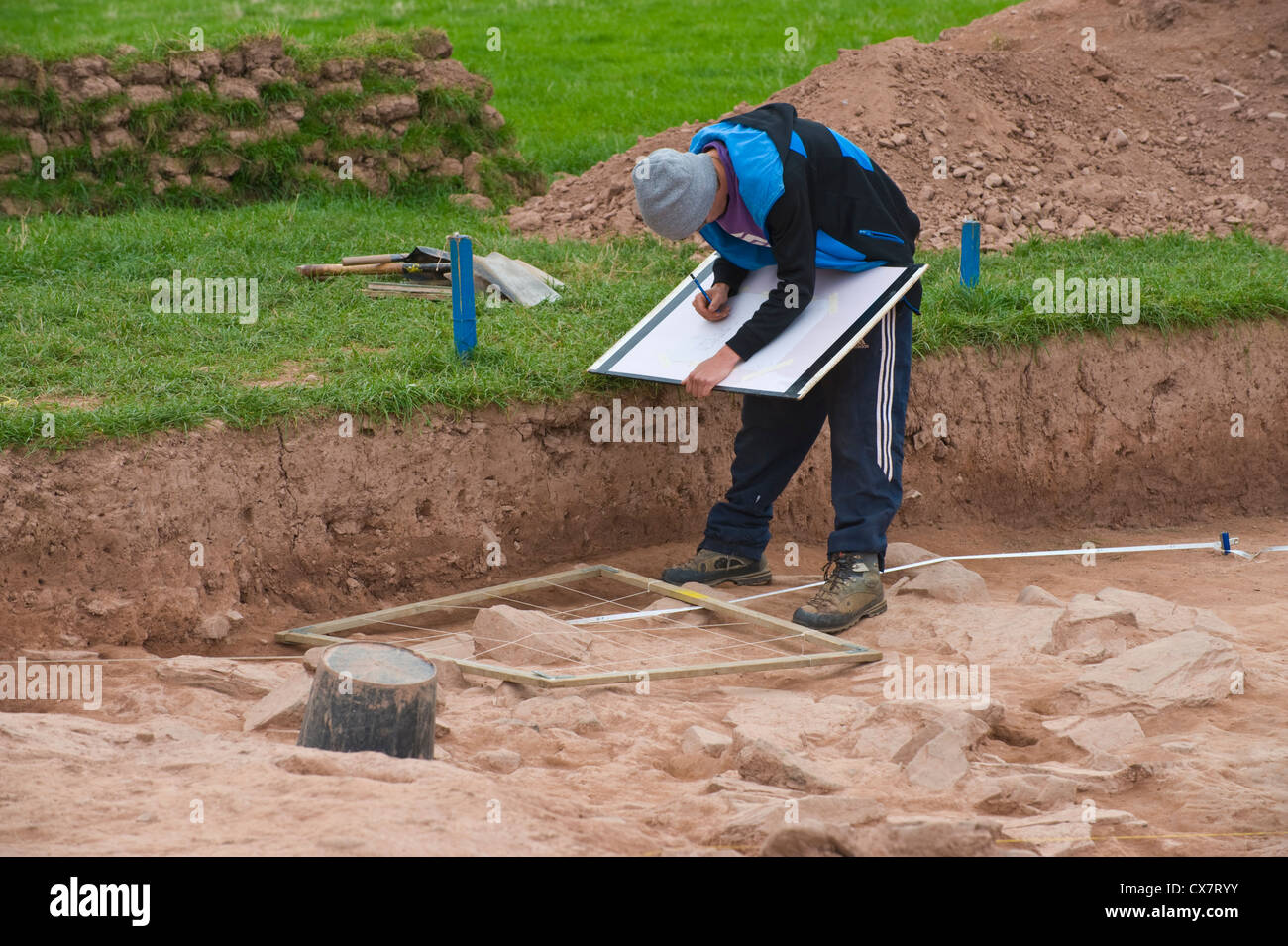 Student archaeologist drawing a section on dig at prehistoric neolithic ...