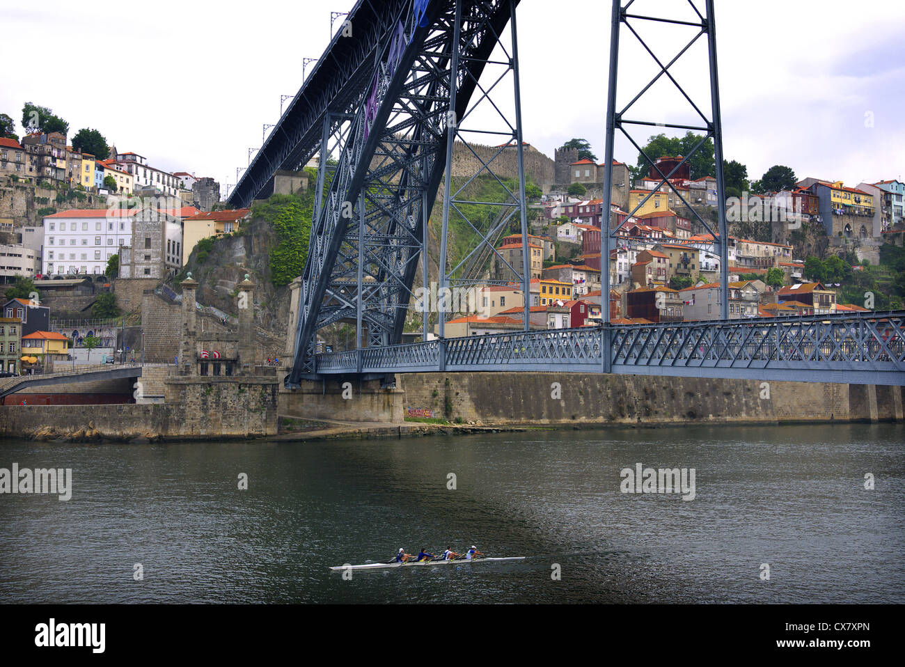 A team of rowers pass under the iron bridge in Porto, Portugal Stock ...