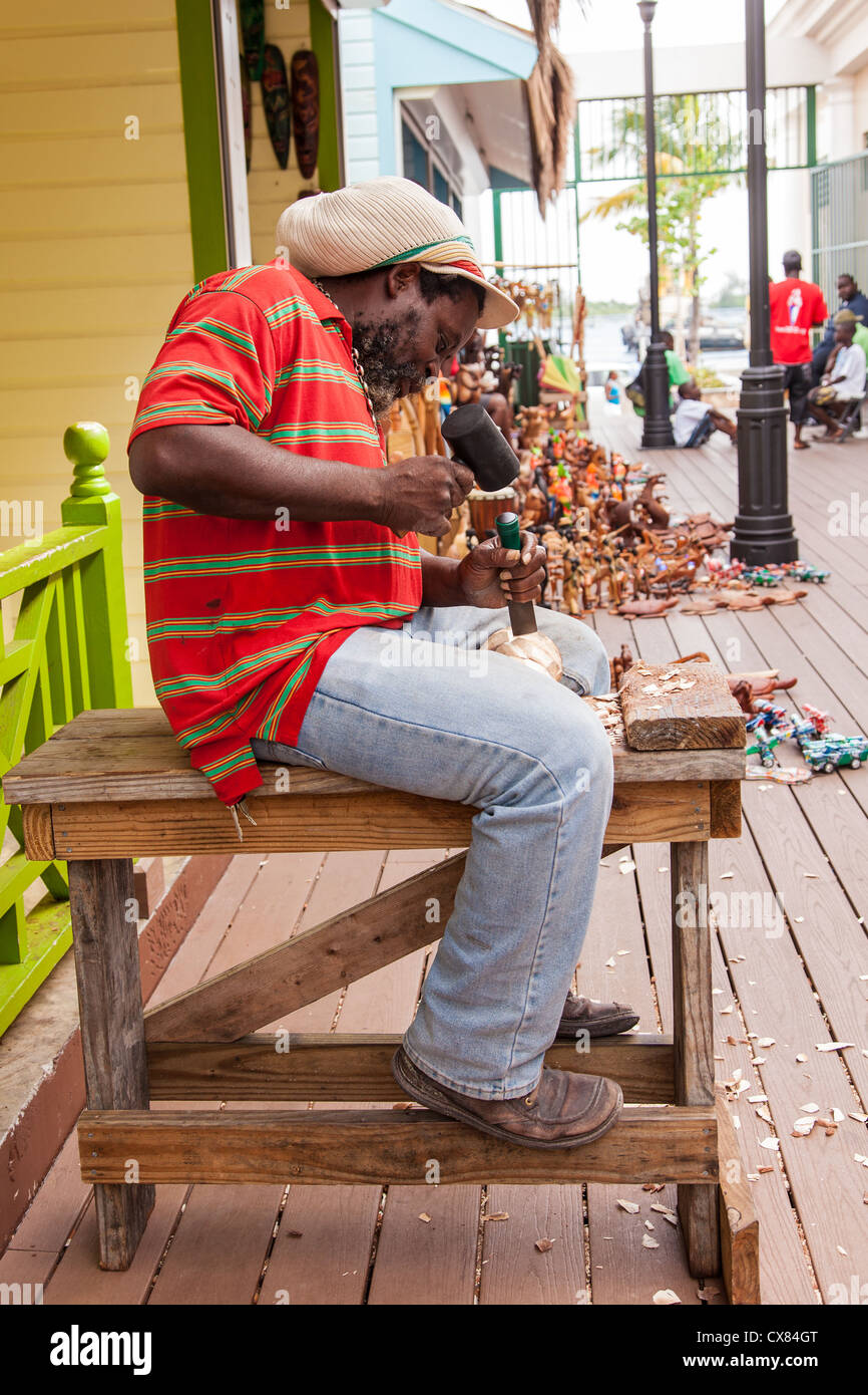 A wood carver works at the Straw Market in Nassau , Bahamas Stock Photo ...