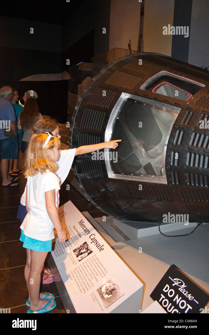 Young girl points out interior of a Mercury Capsule in the Tellus ...
