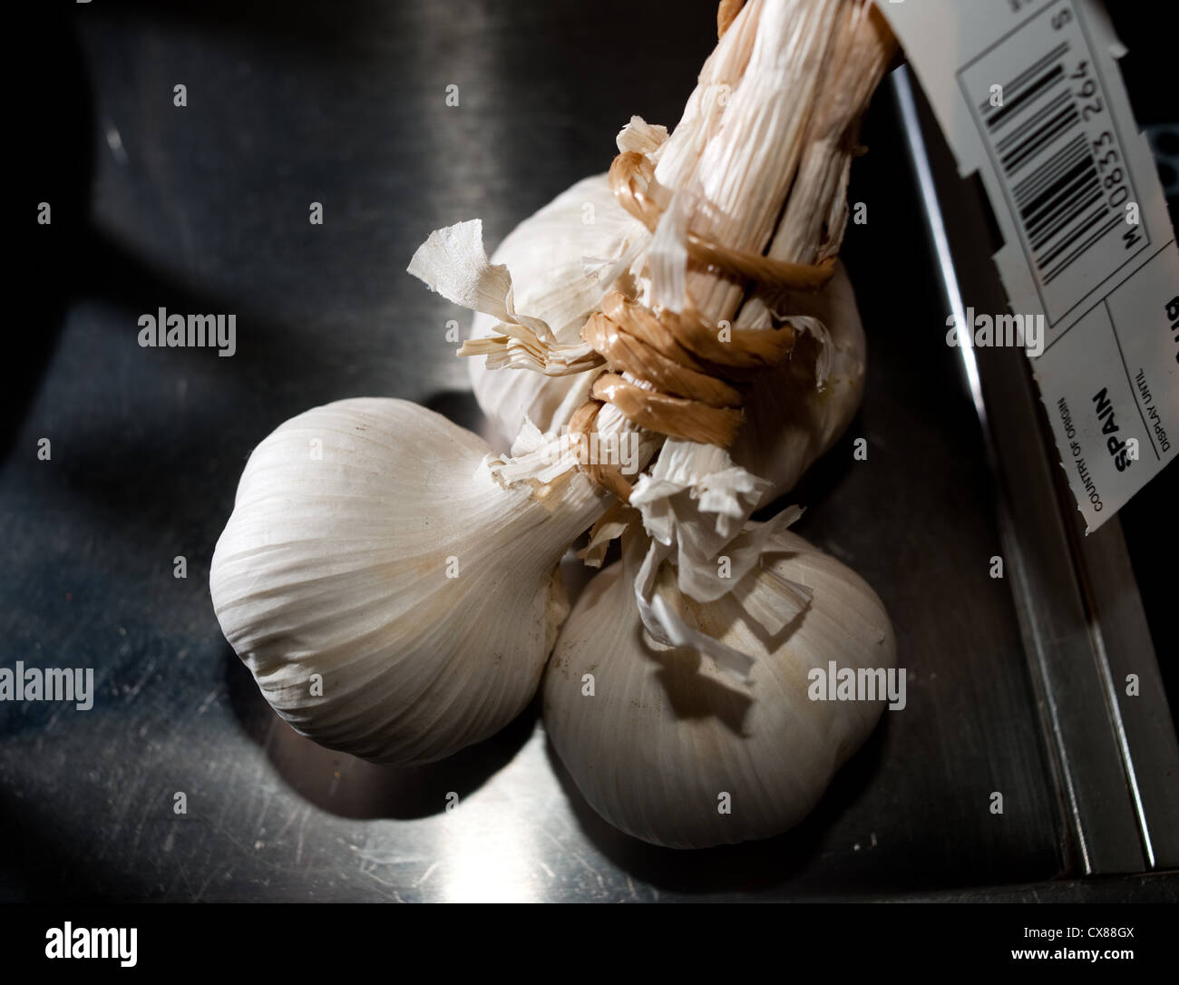 Bulbs of garlic tied together with bar coding price tag UK Stock Photo ...