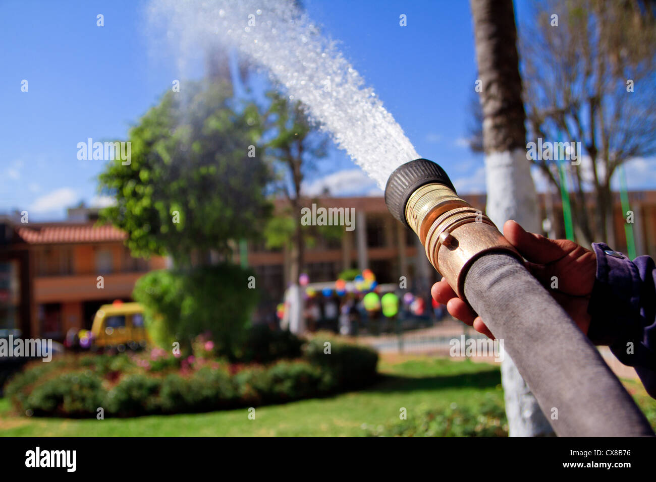 Fireman using water hose to prevent fire spread Stock Photo - Alamy