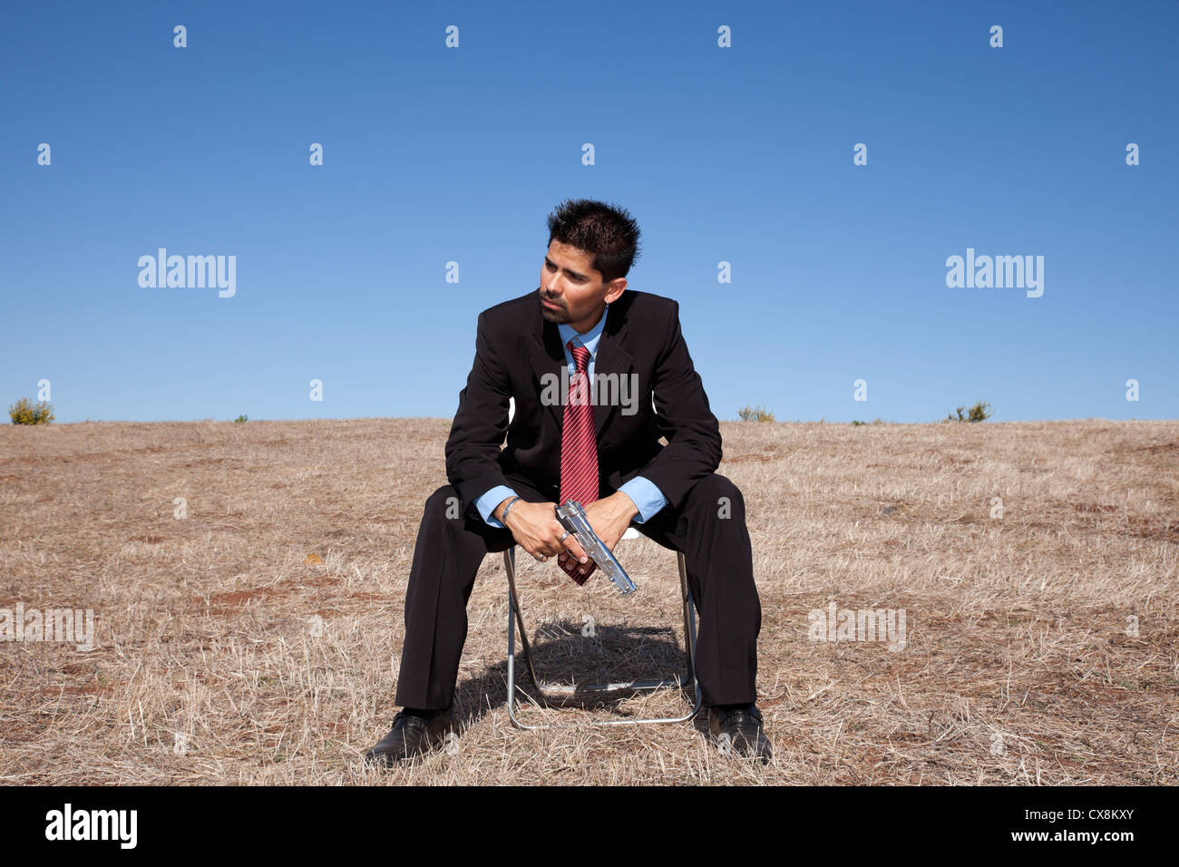 Man with gun in chair hi-res stock photography and images - Alamy