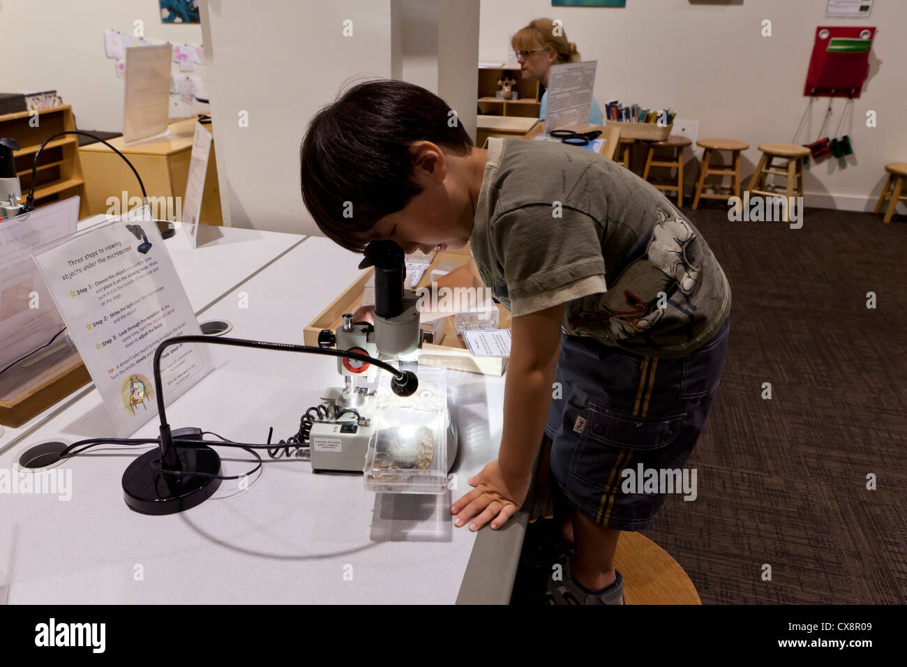 Small child looking in the eyepiece of a microscope Stock Photo - Alamy