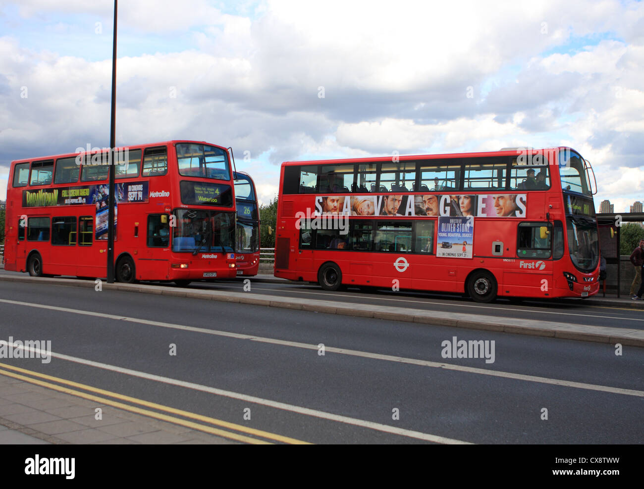 Three double decker red London buses traveling along a road in London ...