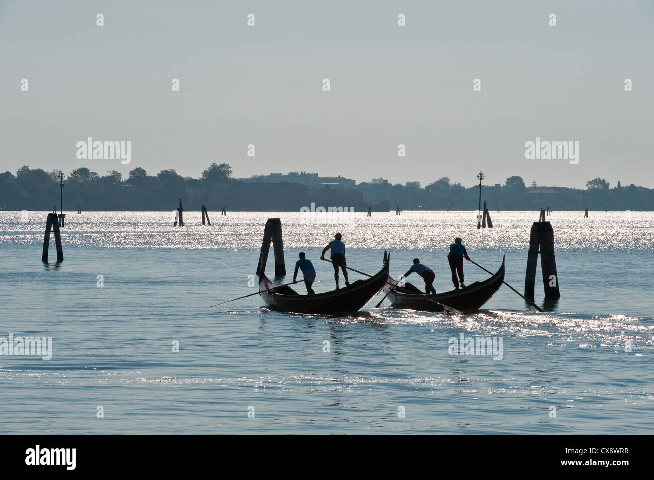 Two traditional wooden sandoli (sandolos) being rowed across the ...