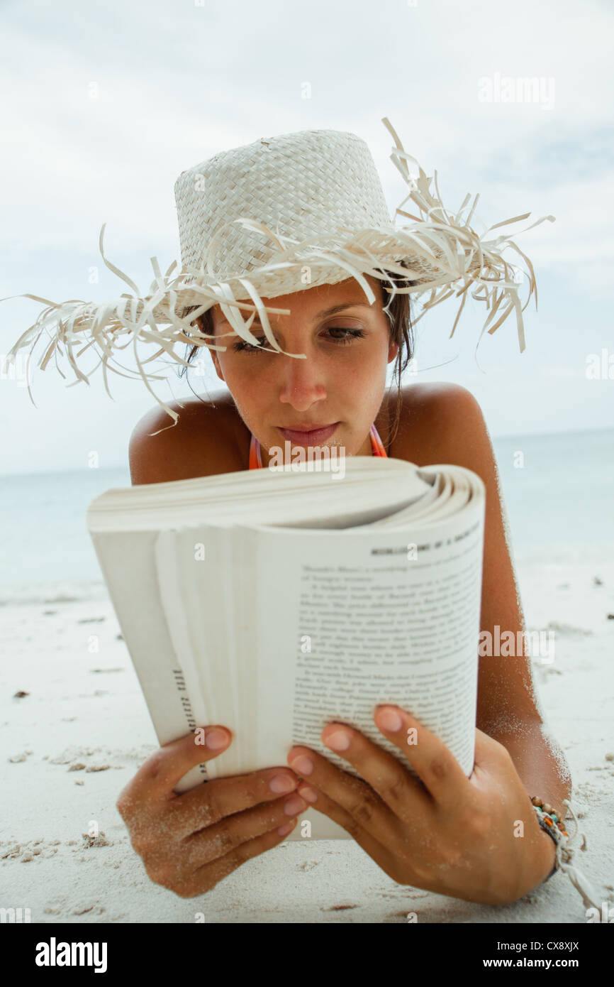 young woman on beach reading book Stock Photo - Alamy
