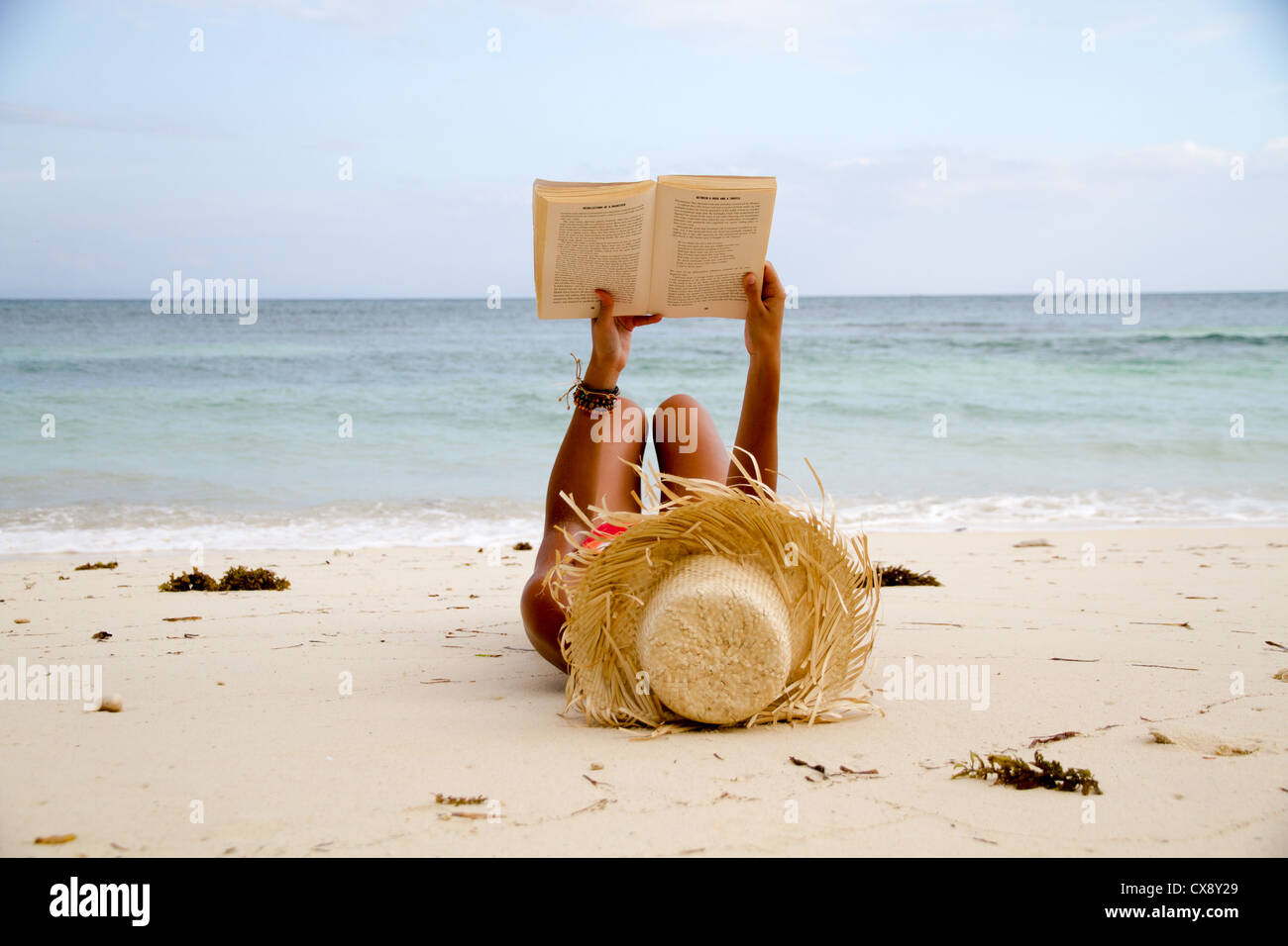 young woman on beach reading book Stock Photo - Alamy