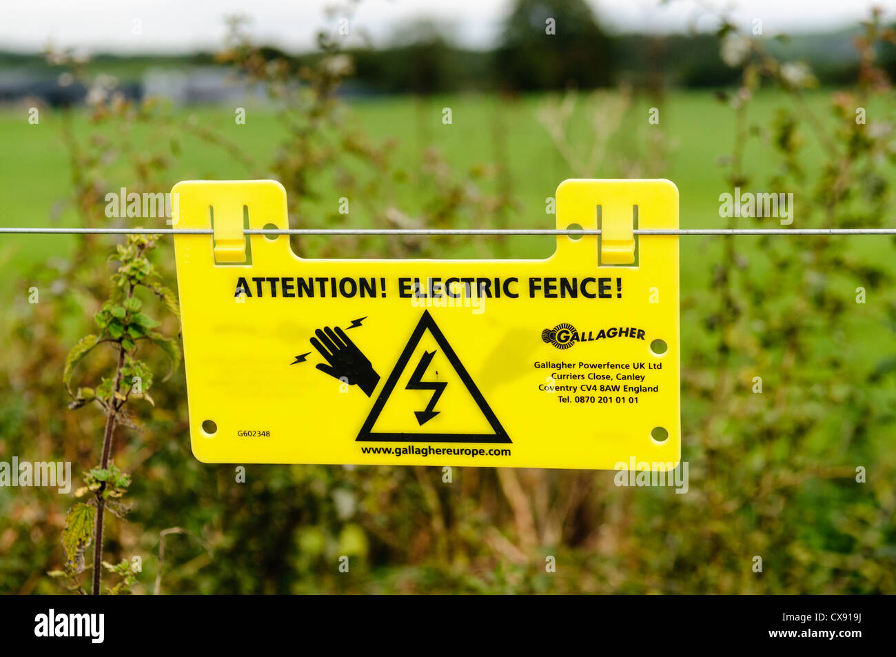 Warning sign on an electric fence around a field Stock Photo - Alamy