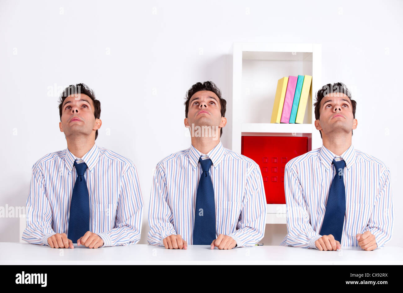 Three businessman at the office desk looking up Stock Photo - Alamy