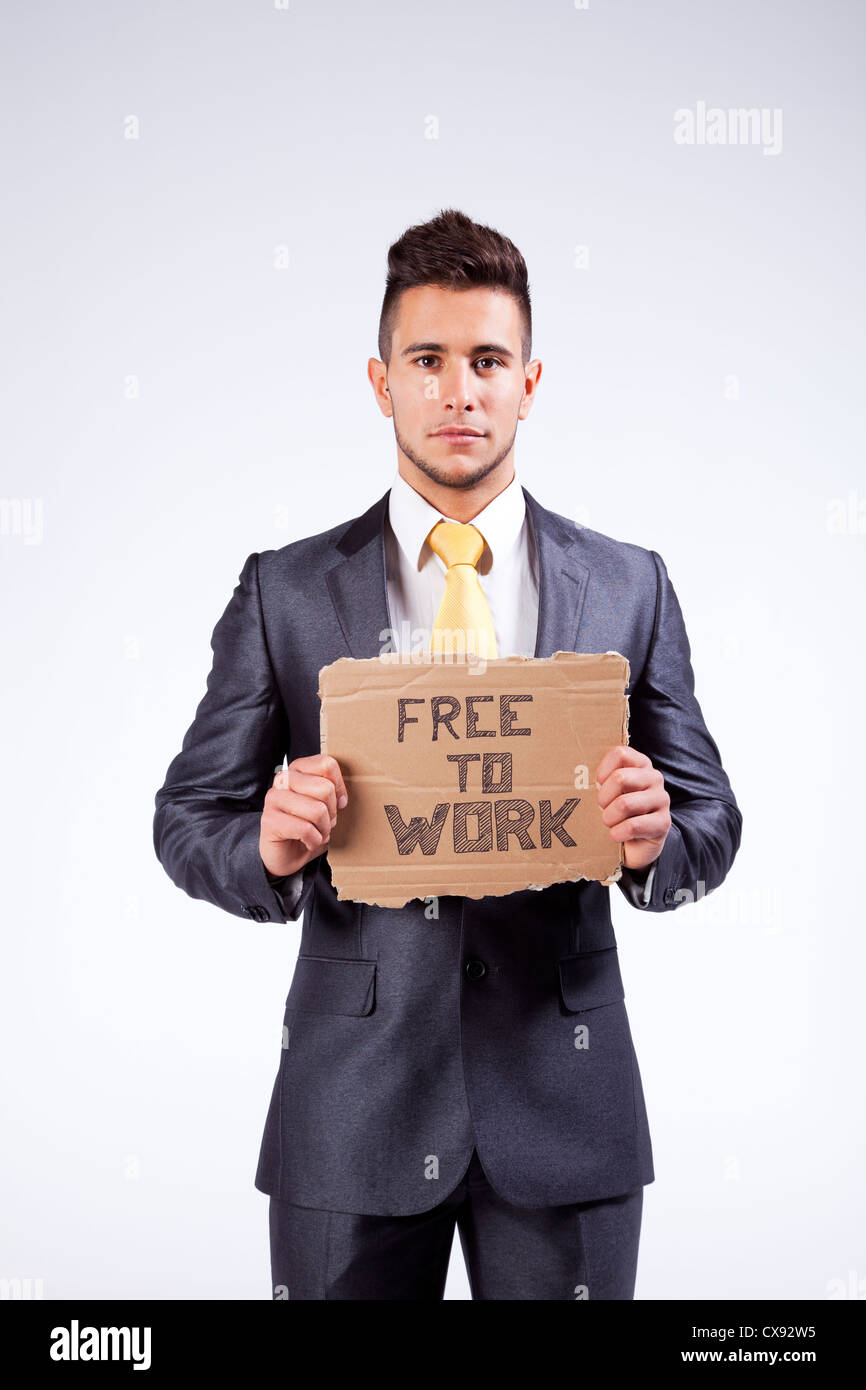 Young businessman holding a piece of cardboard saying Free to Work ...