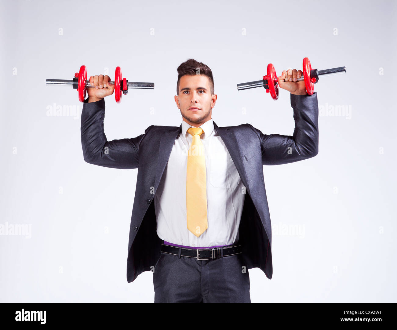 Strong businessman lifting heavy weights Stock Photo - Alamy