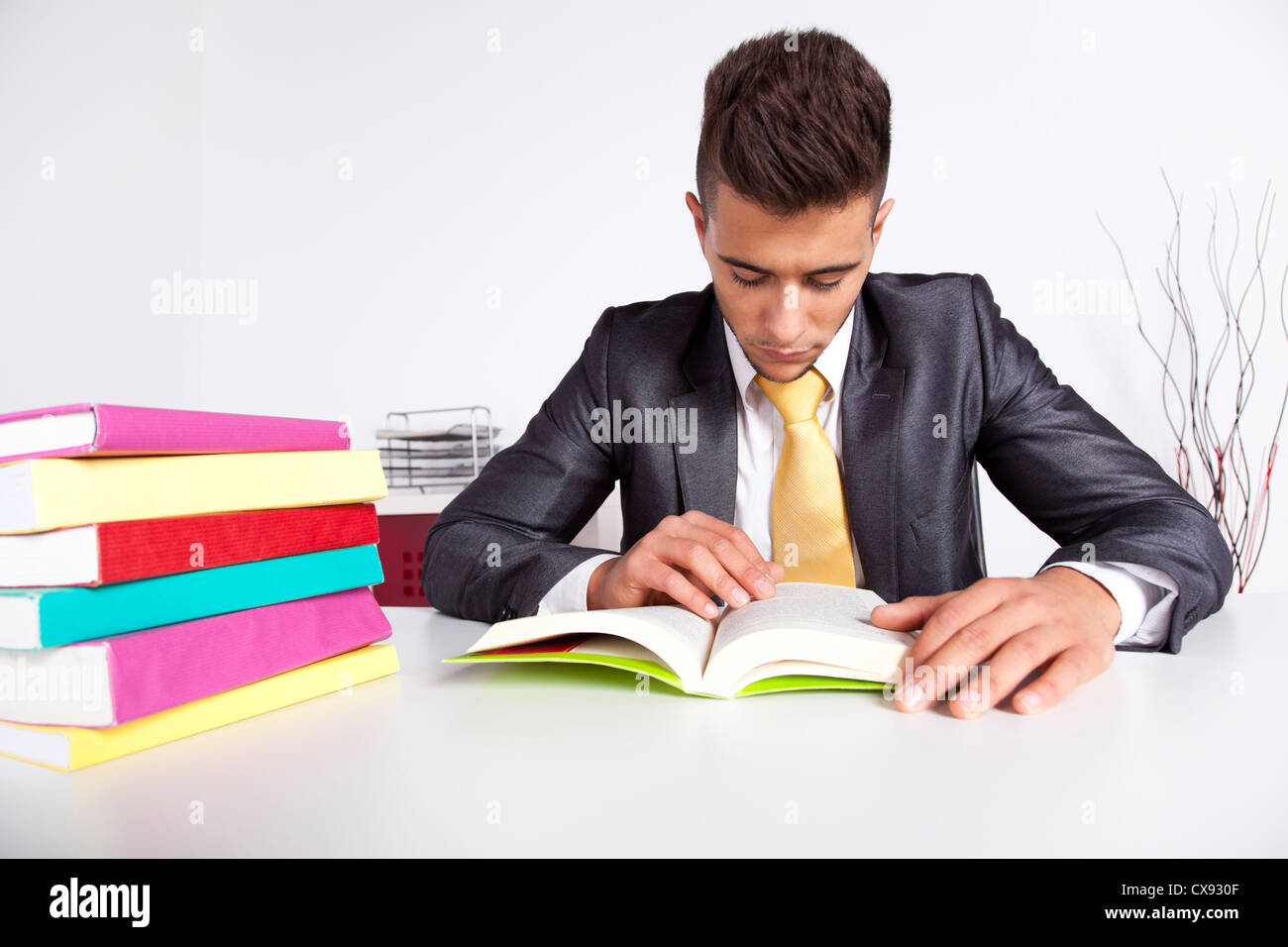 Handsome businessman reading a book in his office Stock Photo - Alamy