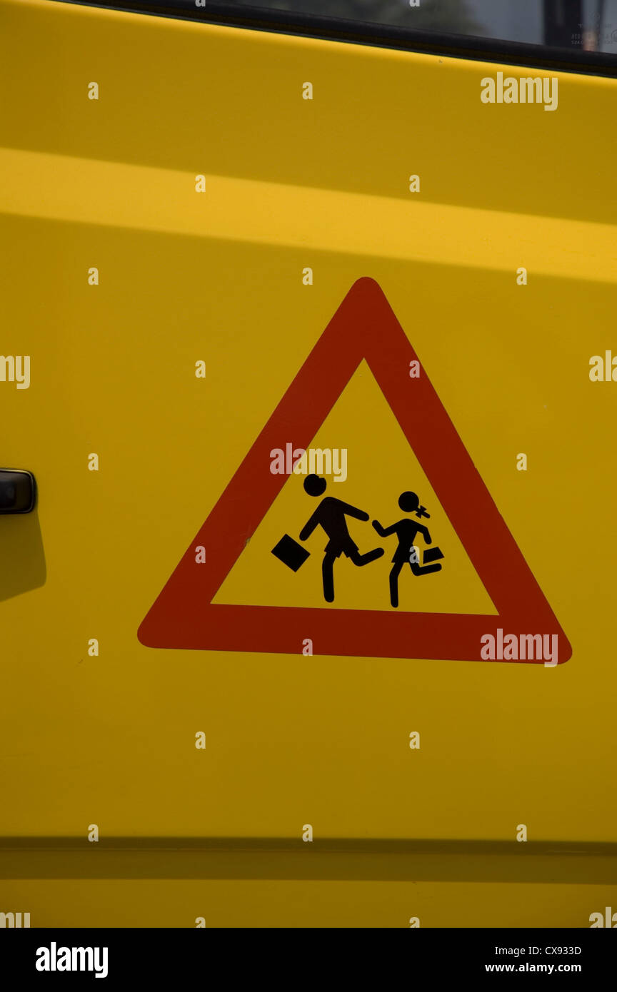 Yellow school bus door with warning triangle alerting you to be aware ...