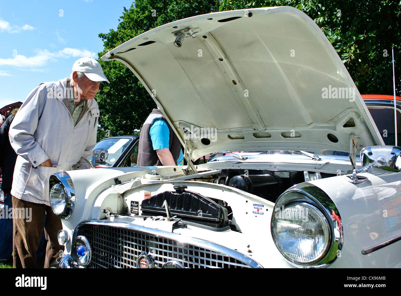 An elderly man looks into the engine of a vintage car Stock Photo - Alamy