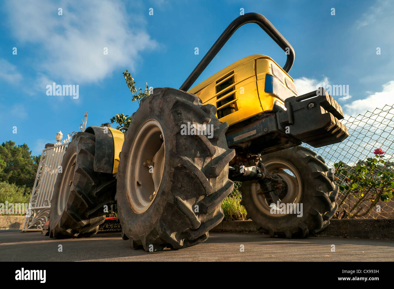 Tractor in the field with a blue sky Stock Photo - Alamy