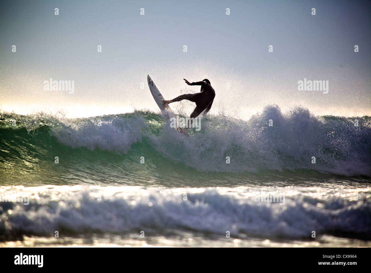 a surfer performs a forward 360 turn on a wave during the summer on the ...