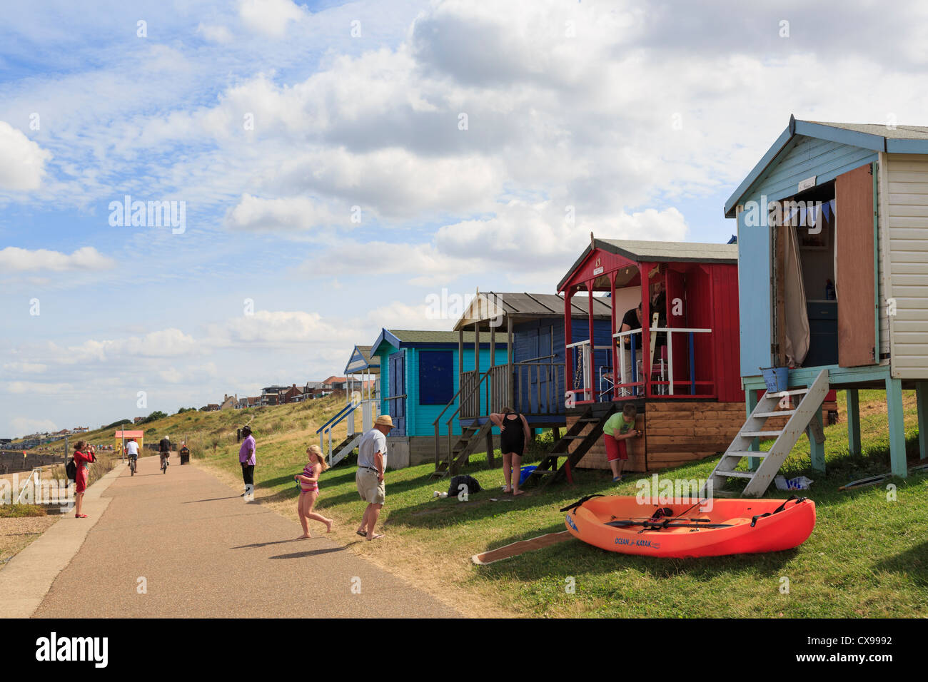 People on Whitstable seafront promenade with beach huts on north Kent ...
