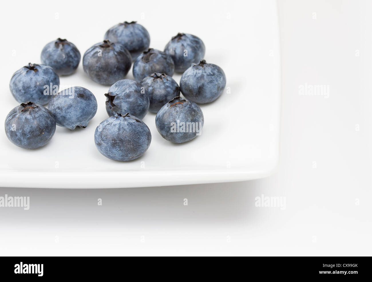 Blueberries on a white square plate Stock Photo - Alamy