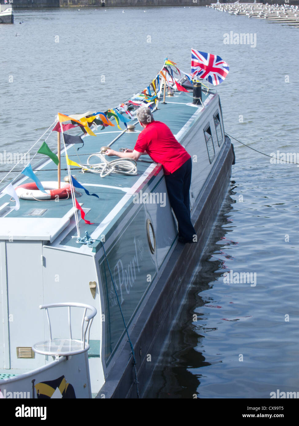traditional british canal longboat flying union jack moored in marina ...